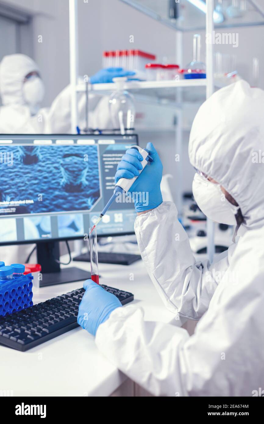 Scientist taking blood sample from test tube using micropipette. Doctor ...