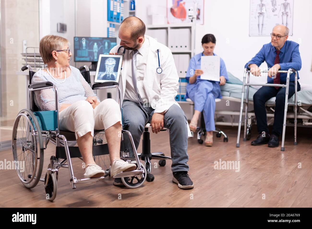 Physician explaining diagnosis to handicapped senior woman in ...