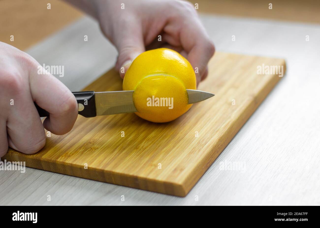 Cut the lemon.Men's hands slice a lemon Stock Photo - Alamy