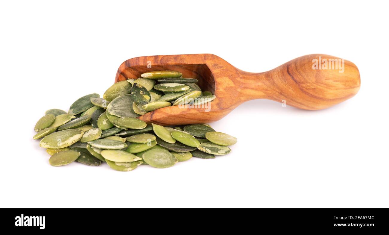 Pumpkin seeds in wooden scoop, isolated on white background. Green ...