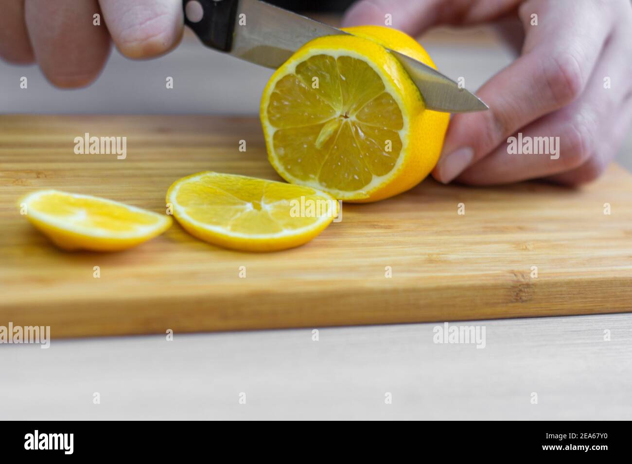 Cut the lemon.Men's hands slice a lemon Stock Photo - Alamy