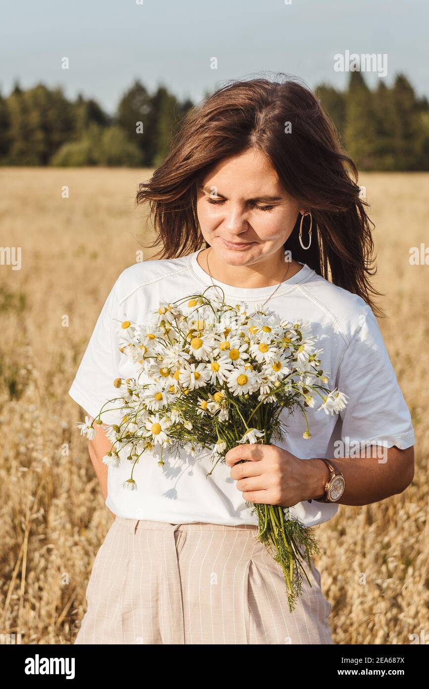 Portrait of the young beautiful smiling woman outdoors in field. Close ...