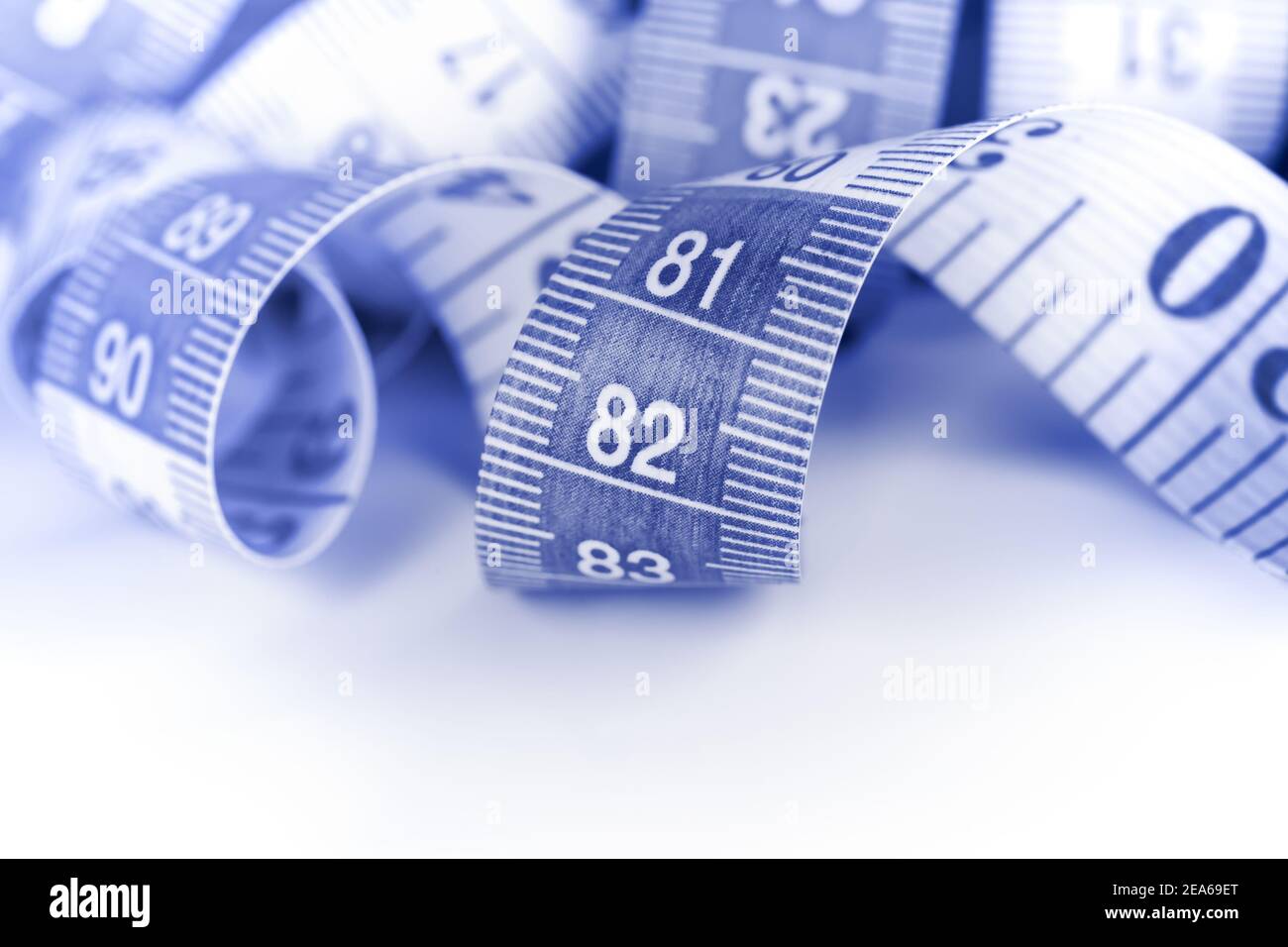 Measuring tape, coiled. Image toned in blue, close-up Stock Photo - Alamy