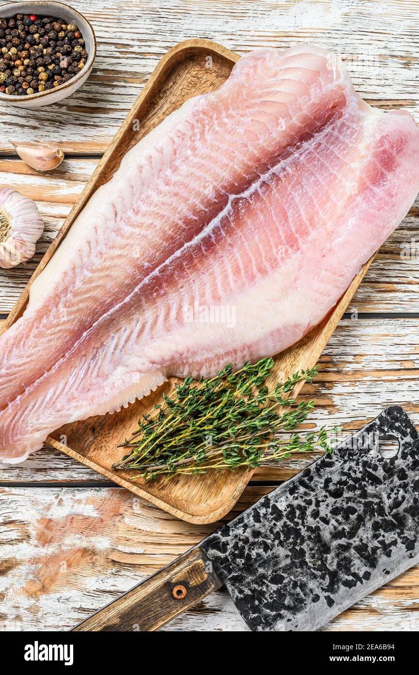 Fresh raw white fish fillet catfish with spices. White wooden ...