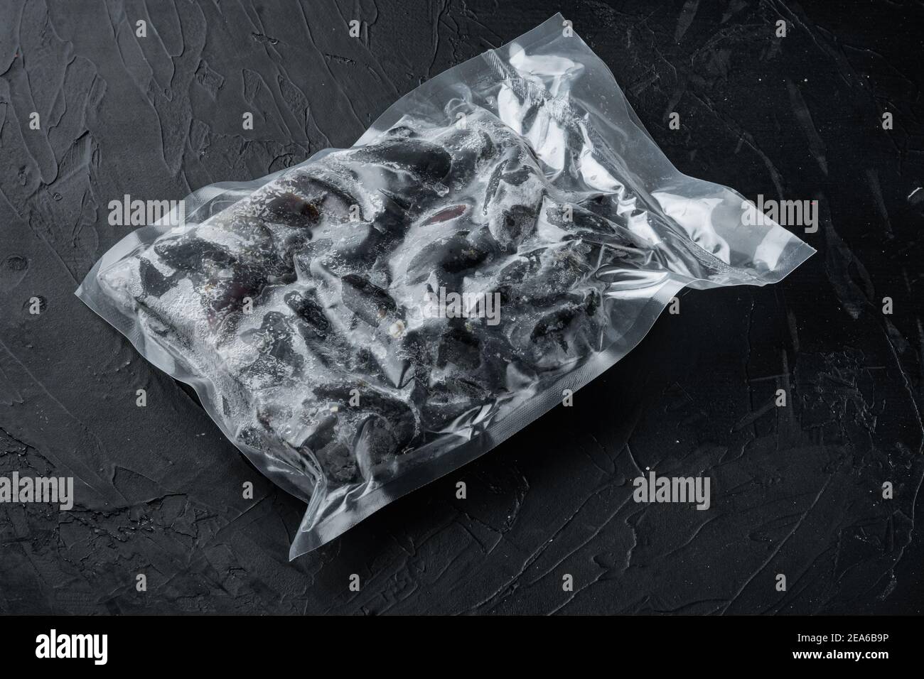 Vacuum packed whole shell mussels frozen, on black background Stock ...