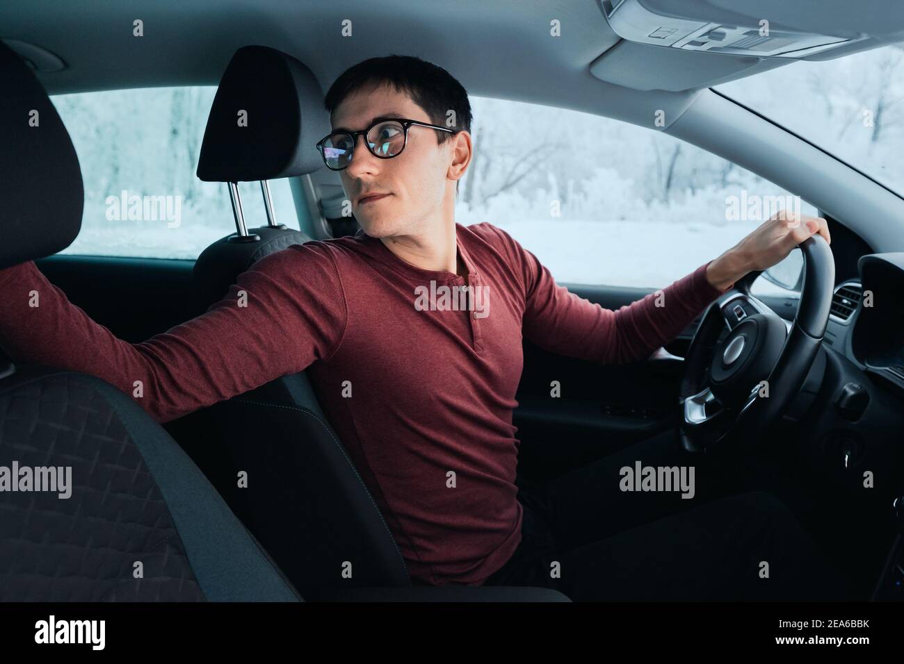 Driver man with glasses turned back for a better view while the car was ...