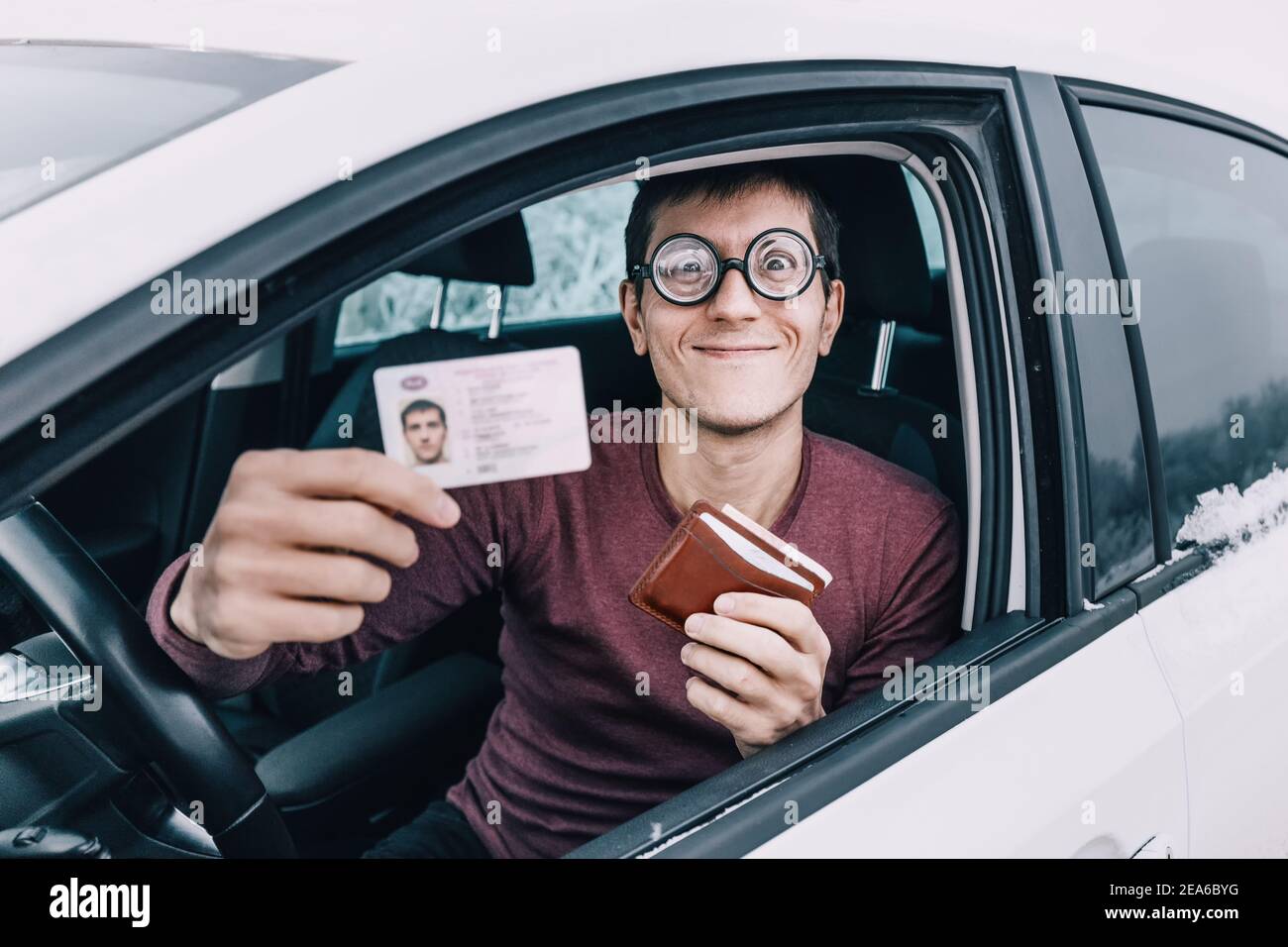 Funny nerd and geek in huge ridiculous glasses shows his drivers ...