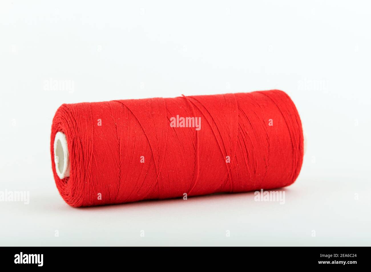 Red colored Spools of Thread on white background Stock Photo - Alamy