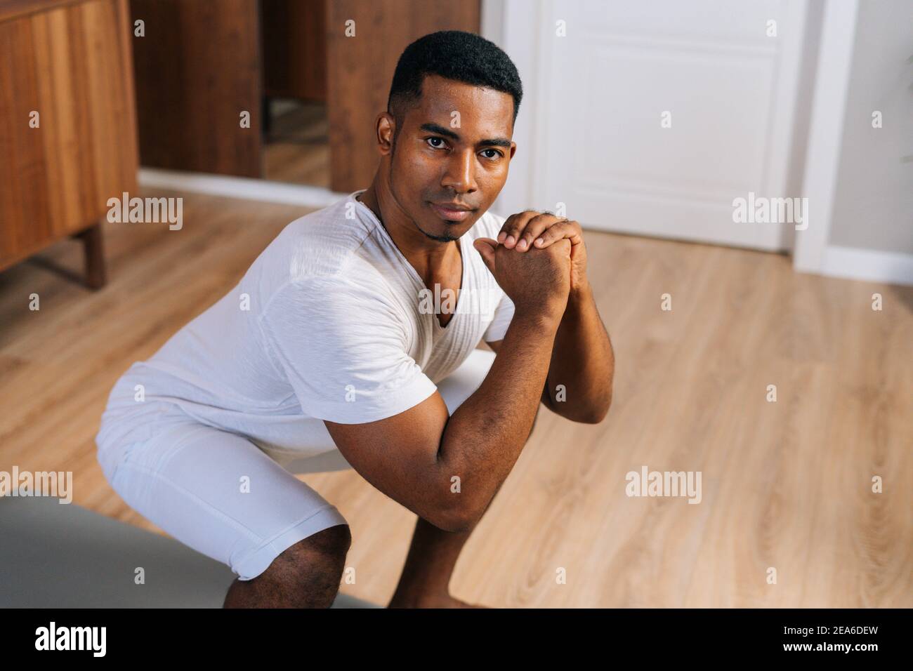 Close-up side view of serious African-American man exercising and ...