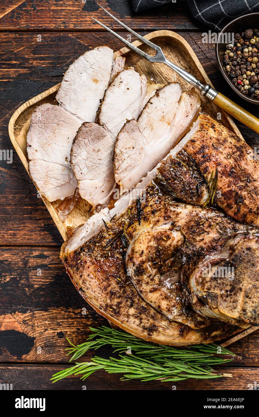 Baked sliced pork leg knuckle. Dark wooden background. Top view Stock ...