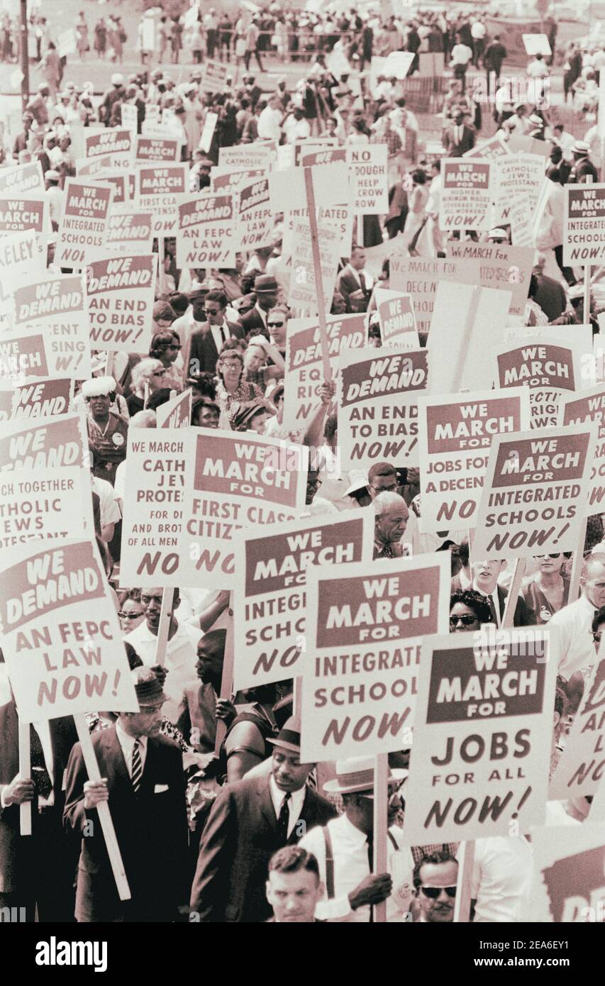 Demonstrators marching in the street holding signs during the March on ...