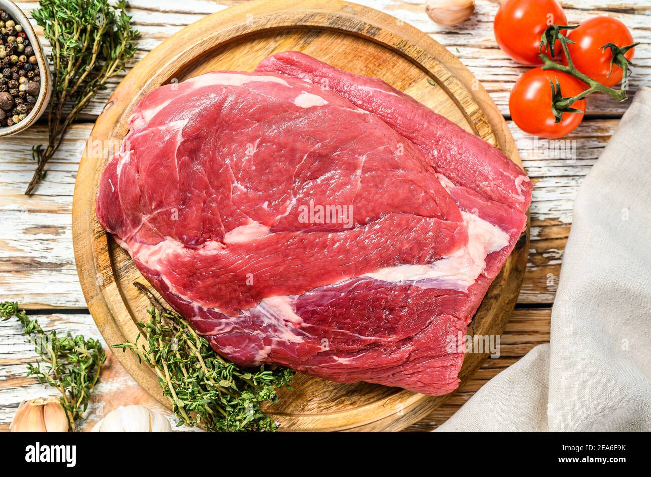 Raw Round beef cut on a wooden board. White background. Top view Stock ...