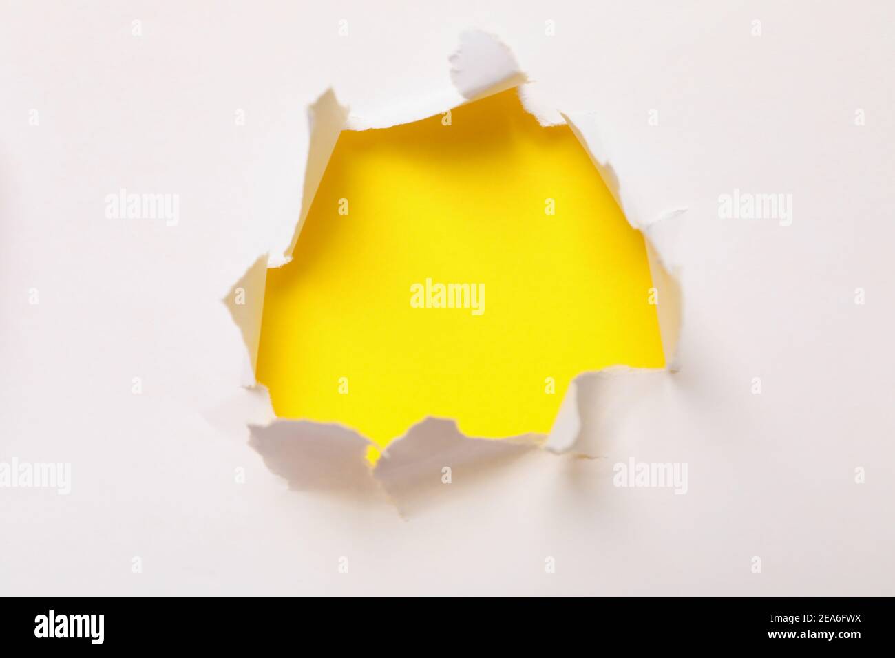 Hole in paper on yellow background, space for text Stock Photo - Alamy
