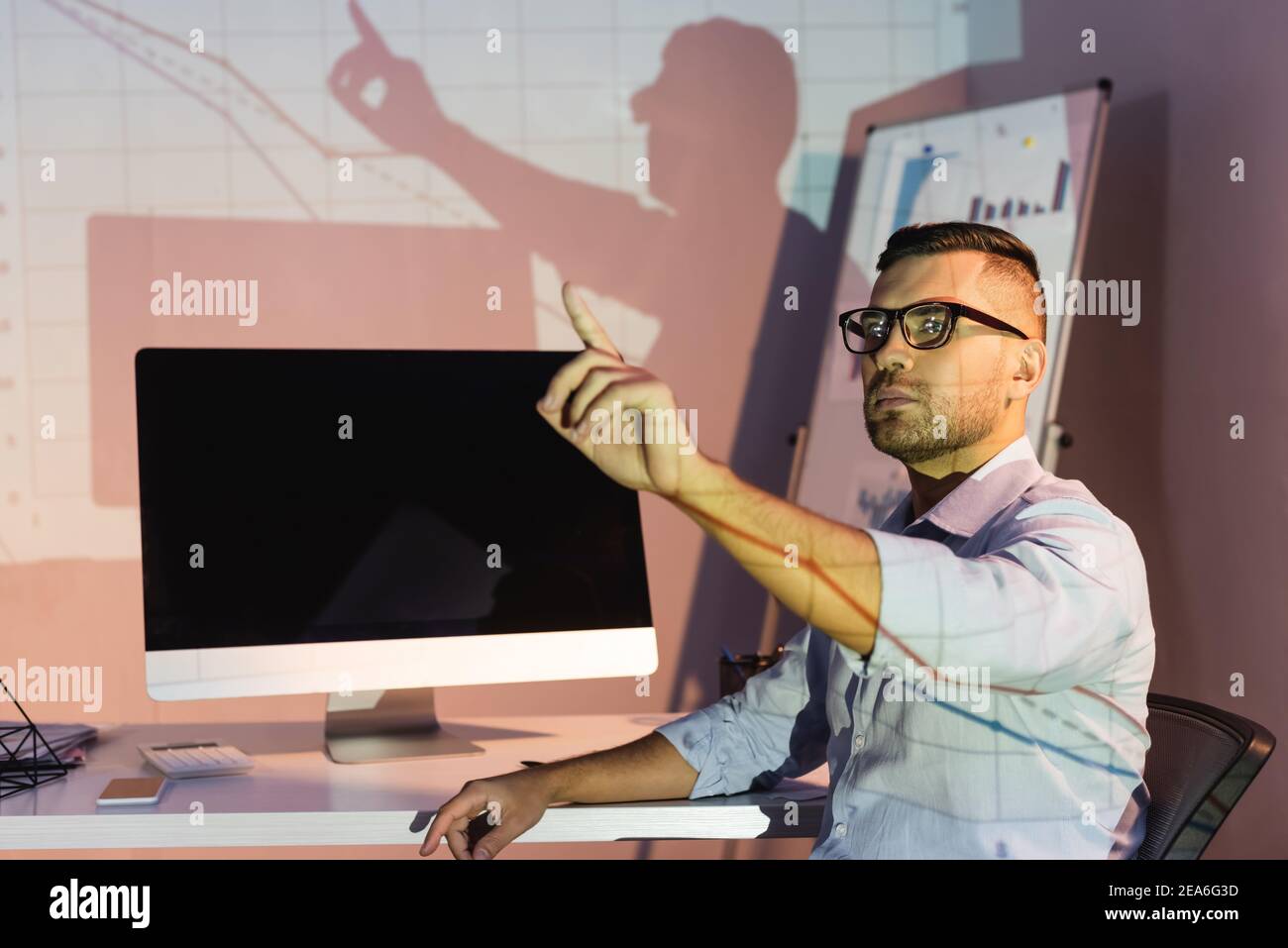 businessman in glasses pointing with finger near computer monitor with ...