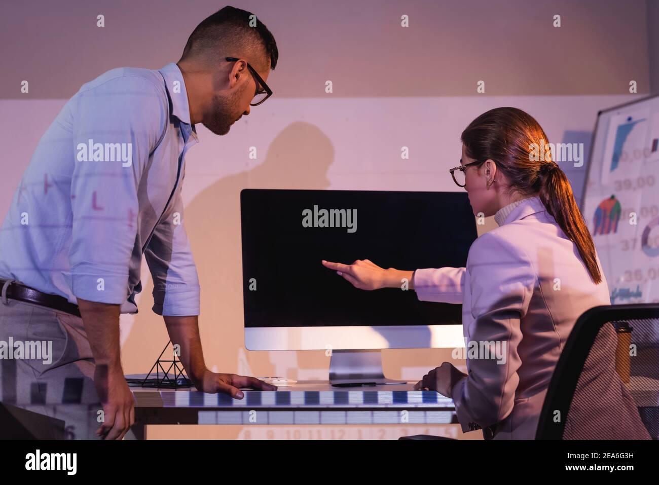 businesswoman in glasses pointing with finger at computer monitor with ...