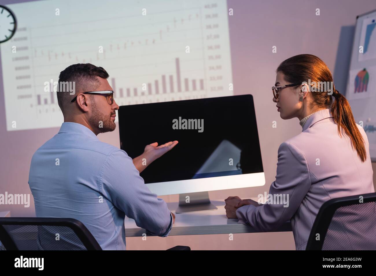 businessman in glasses pointing with hand at computer monitor with ...