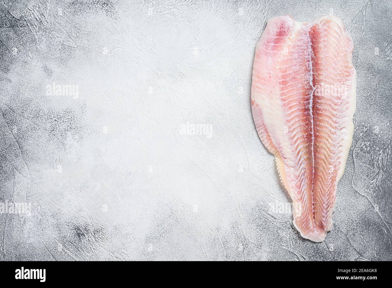 Frozen pangasius fish fillet. Gray background. Top view. Copy space ...