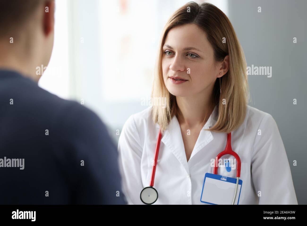 Woman doctor talking to patient in clinic Stock Photo - Alamy