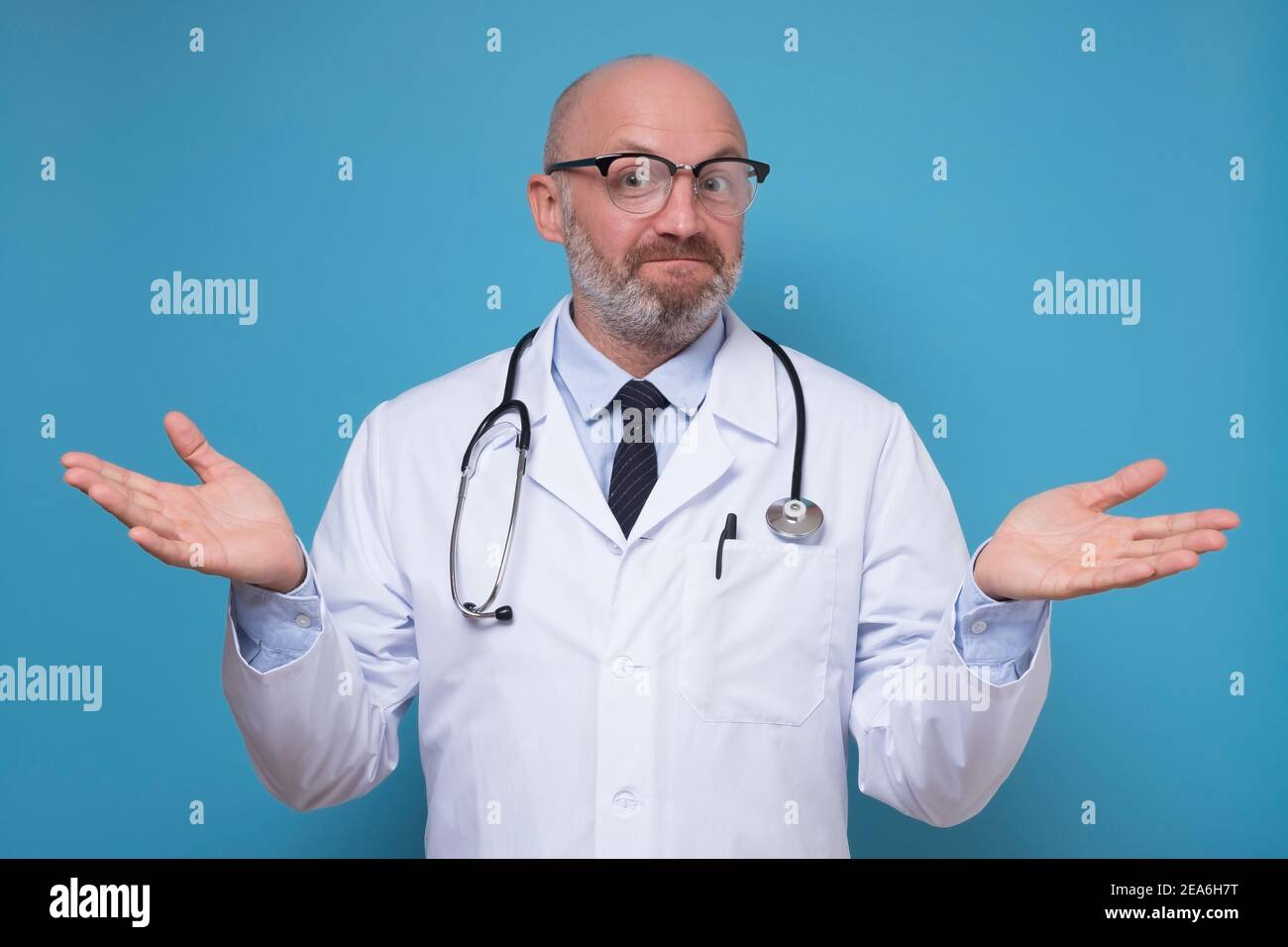 Experienced male doctor standing with open arms asking so how. Studio ...