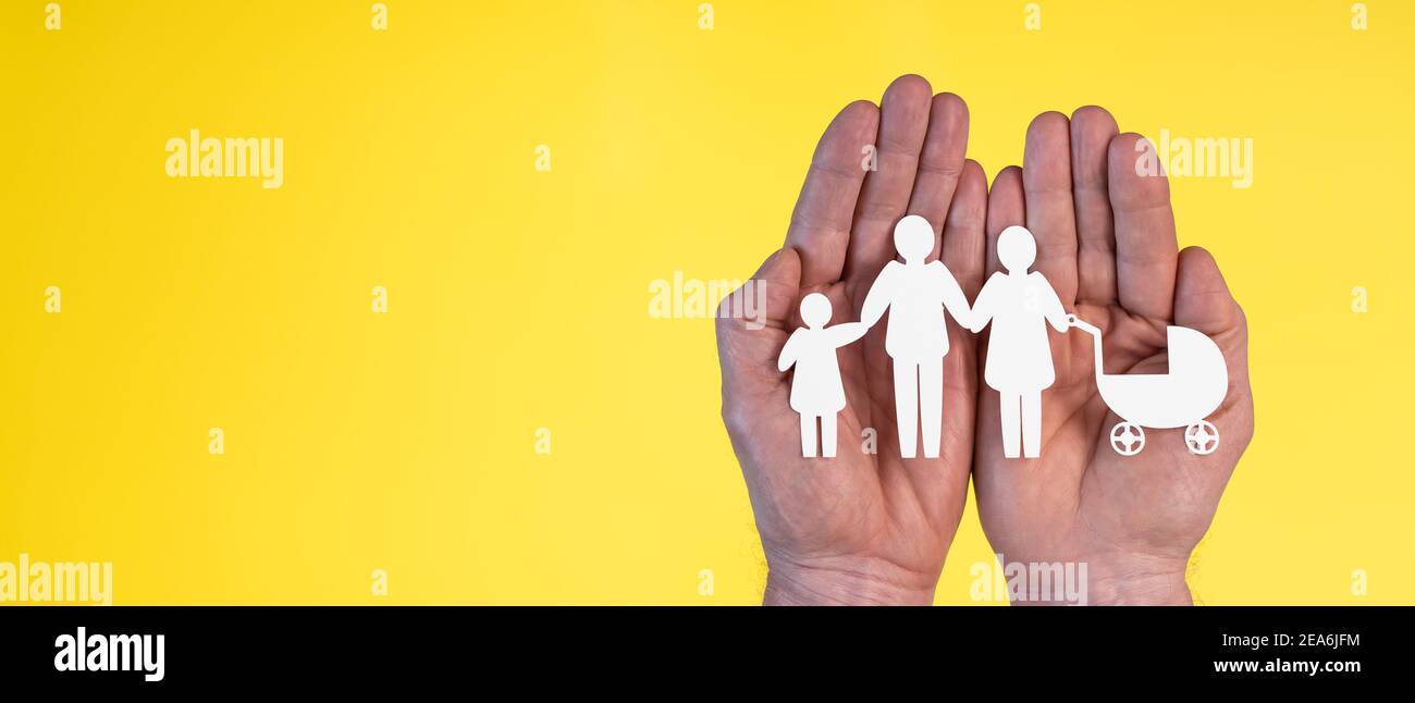 Concept of family insurance with paper family in hands on yellow ...