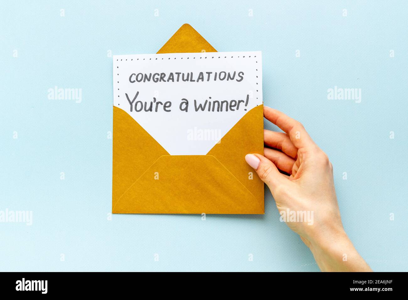Female hand holds envelope with card You are a winner. Congratulations ...