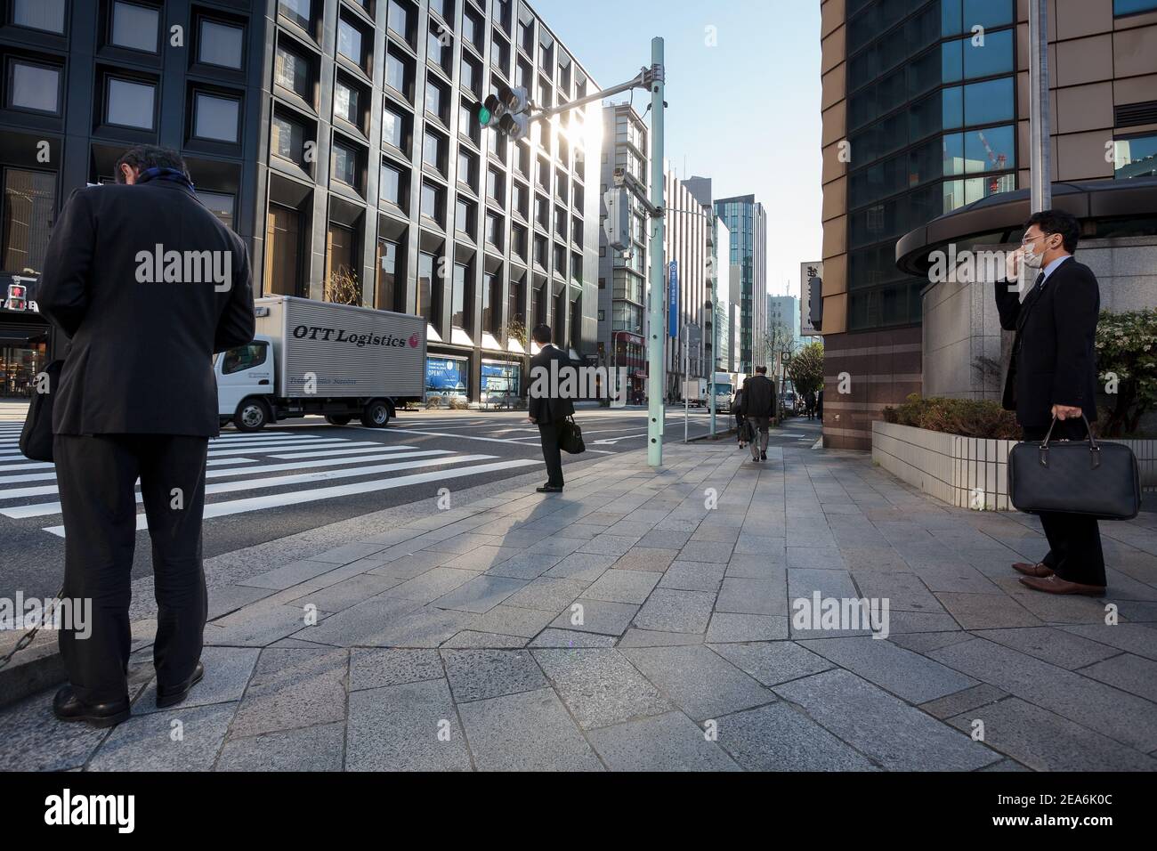 Japanese male office workers or salarymen waiting at a crossing in ...