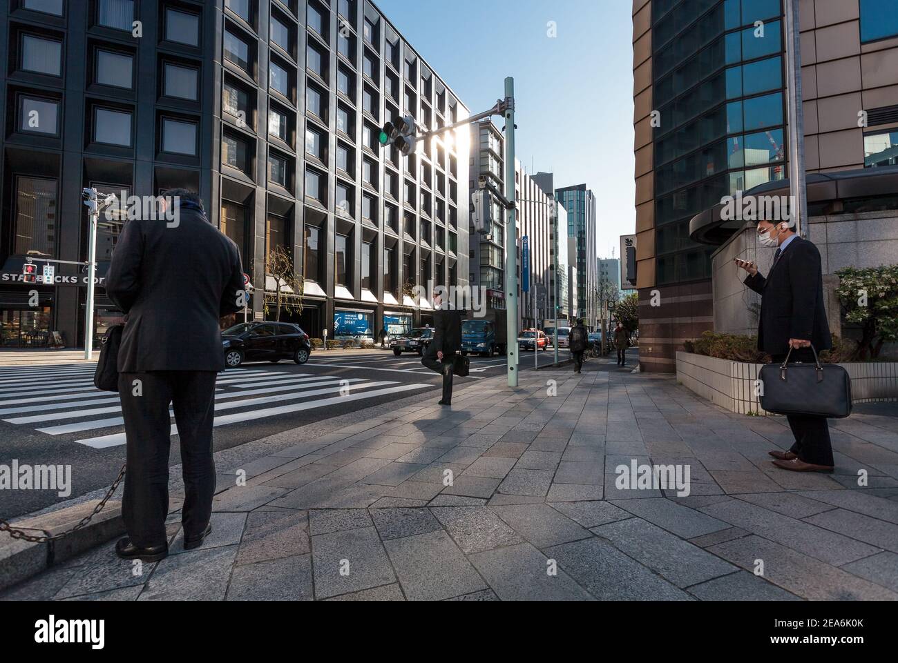Japanese male office workers or salarymen check their smartphones while ...