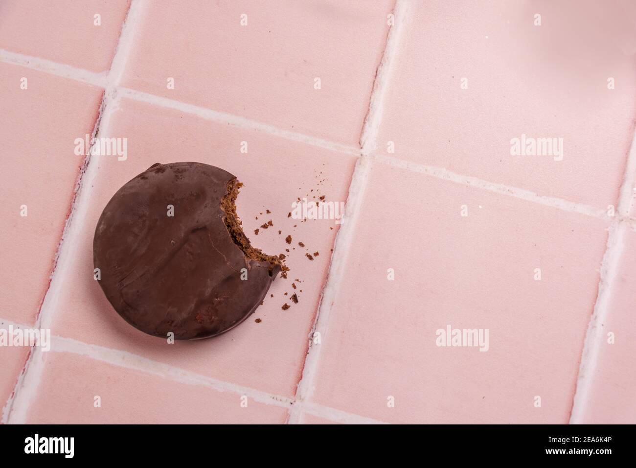 Closeup of a bitten chocolate cookie on pink background Stock Photo - Alamy