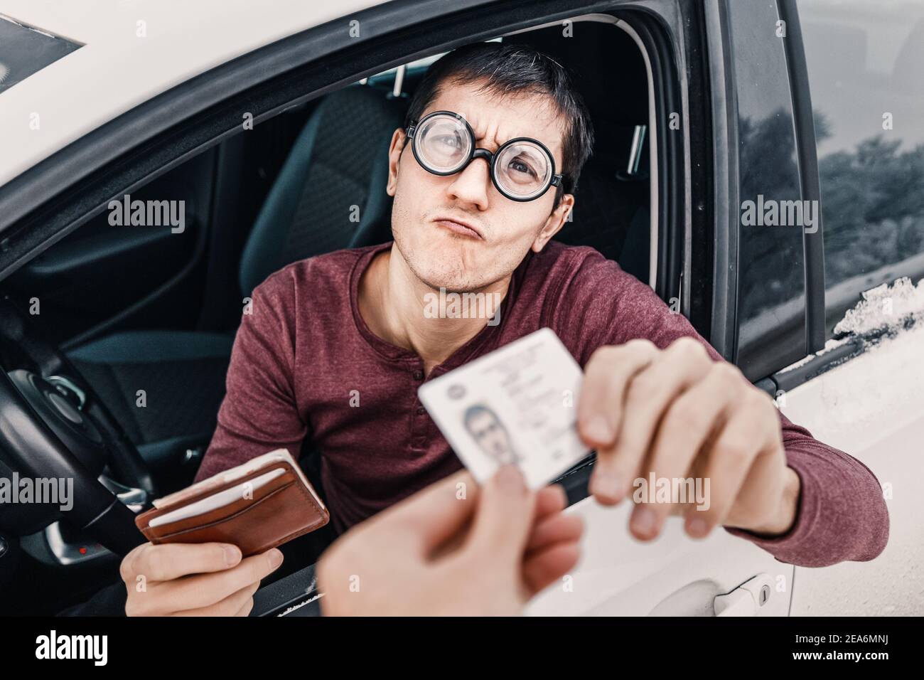 Funny nerd and geek in huge ridiculous glasses shows his drivers ...