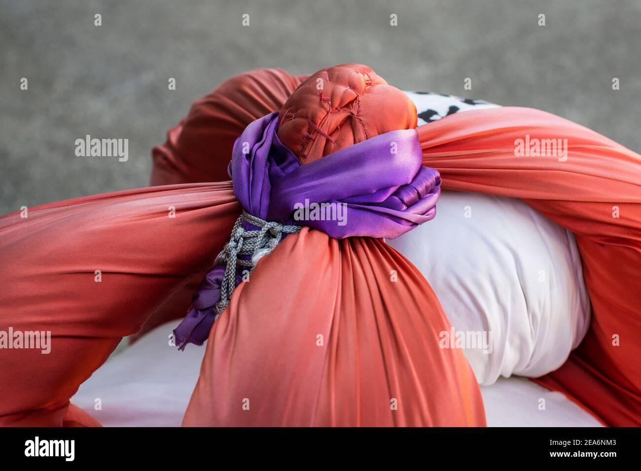 Red and white silk migawarisaru or scapegoat monkeys hanging outside ...