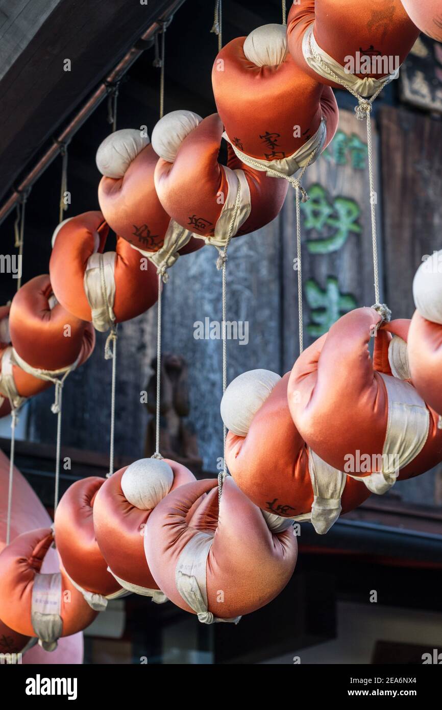 Red and white silk migawarisaru or scapegoat monkeys hanging outside ...