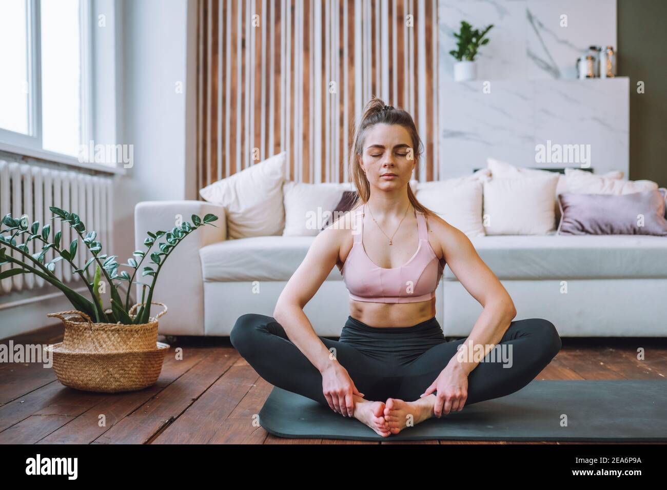 Attractive young woman sit in lotus yoga position at home in living ...