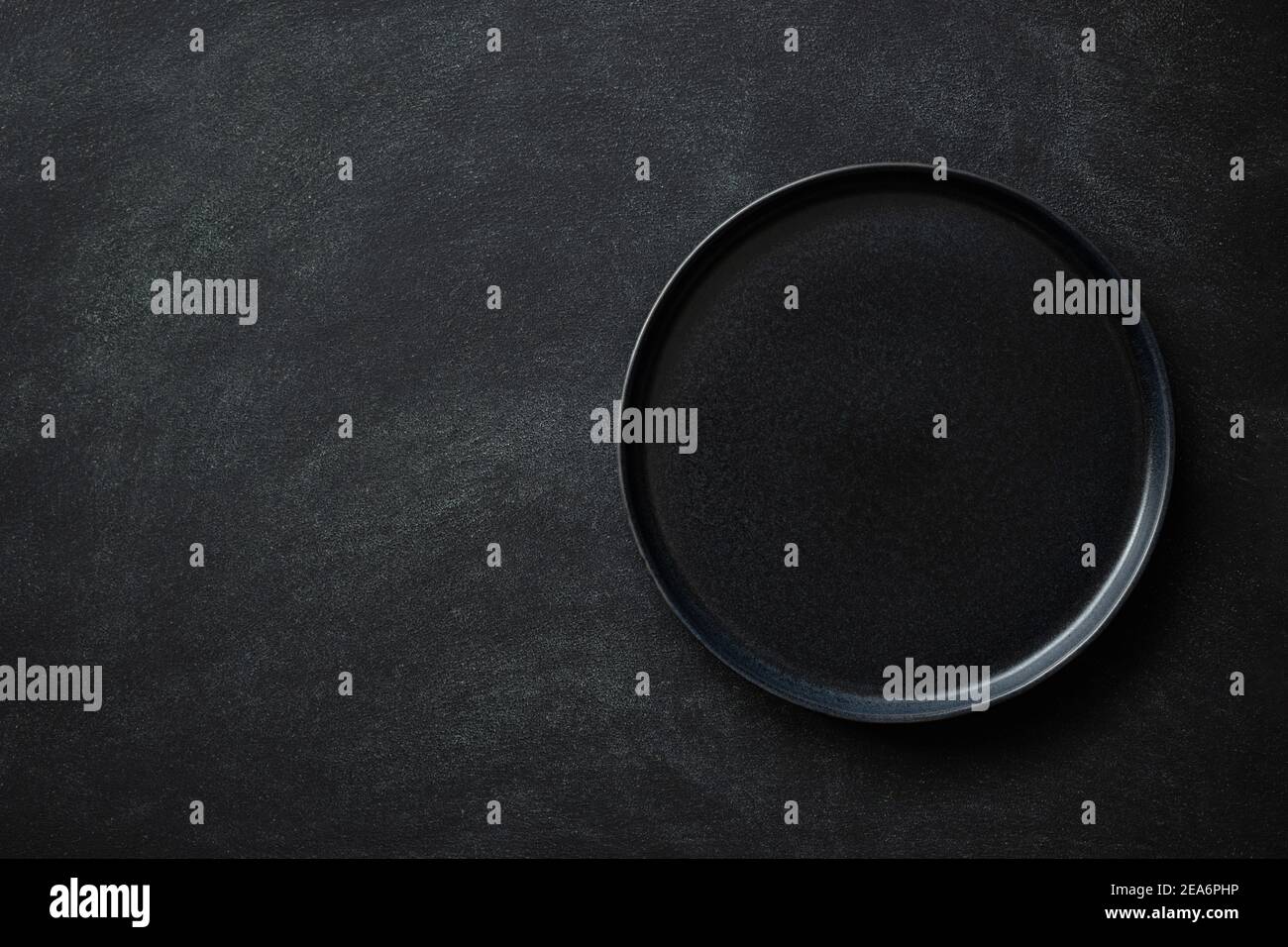 Black background with empty black plate. Top view Stock Photo - Alamy