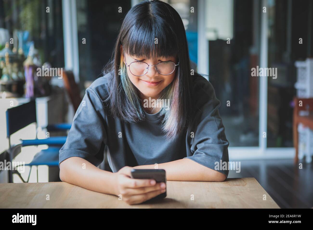 asian teenager reading message on smart phone in hand Stock Photo - Alamy