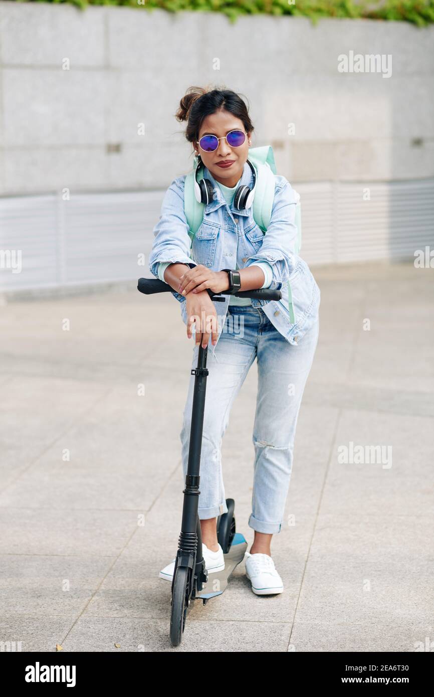 College student leaning on electric scooter Stock Photo - Alamy