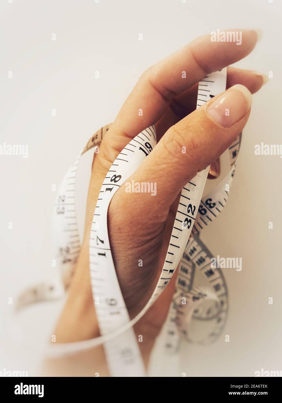 Woman's hand holding a tape measure Stock Photo - Alamy