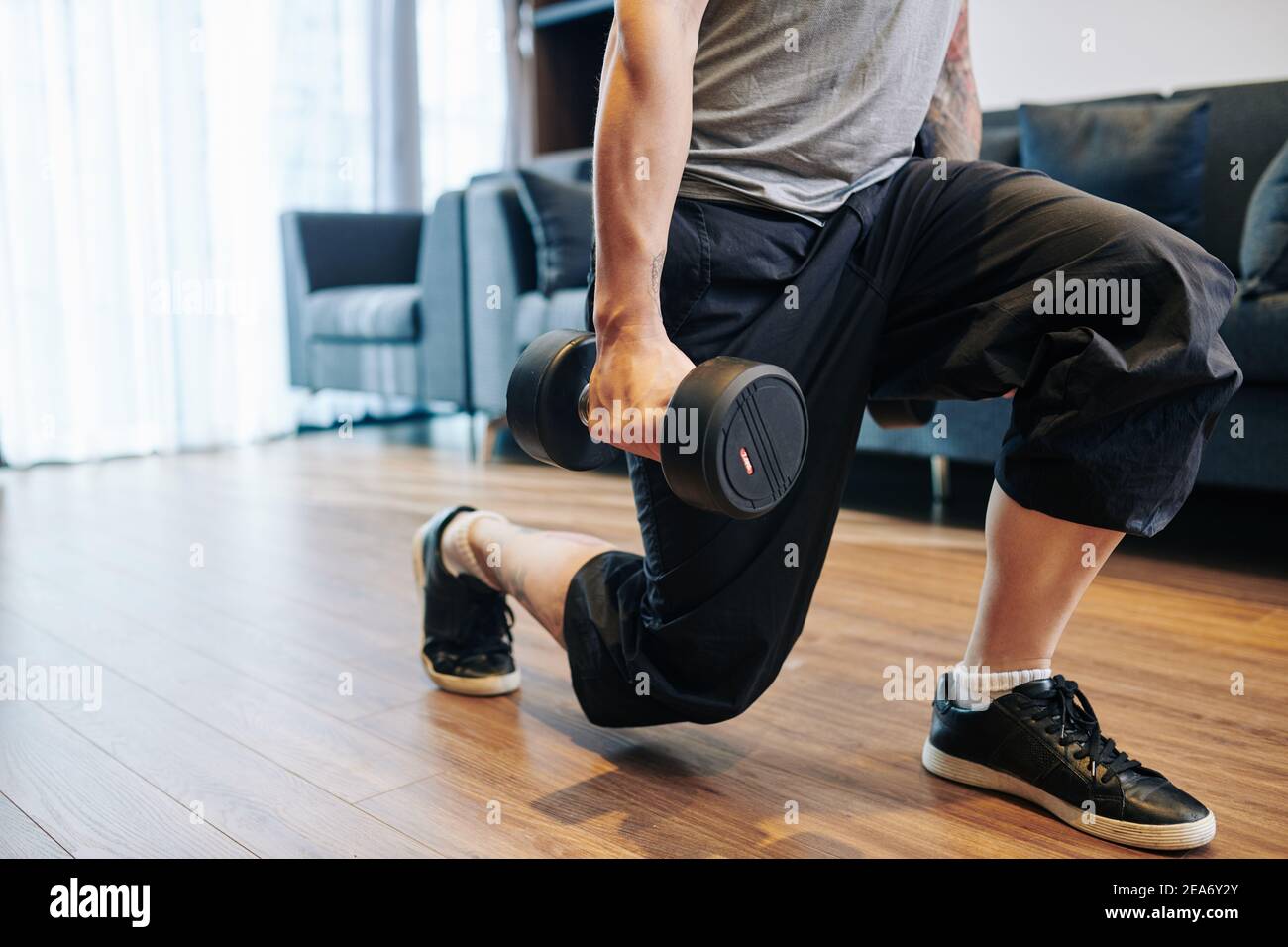 Man doing lunges with dumbbells Stock Photo - Alamy