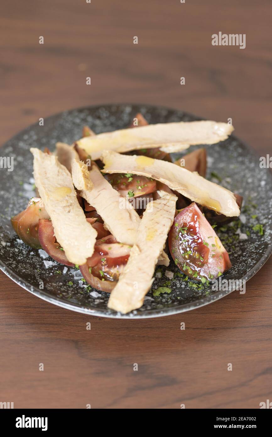 Vertical shot of a salad with fish belly slices and tomatoes Stock ...