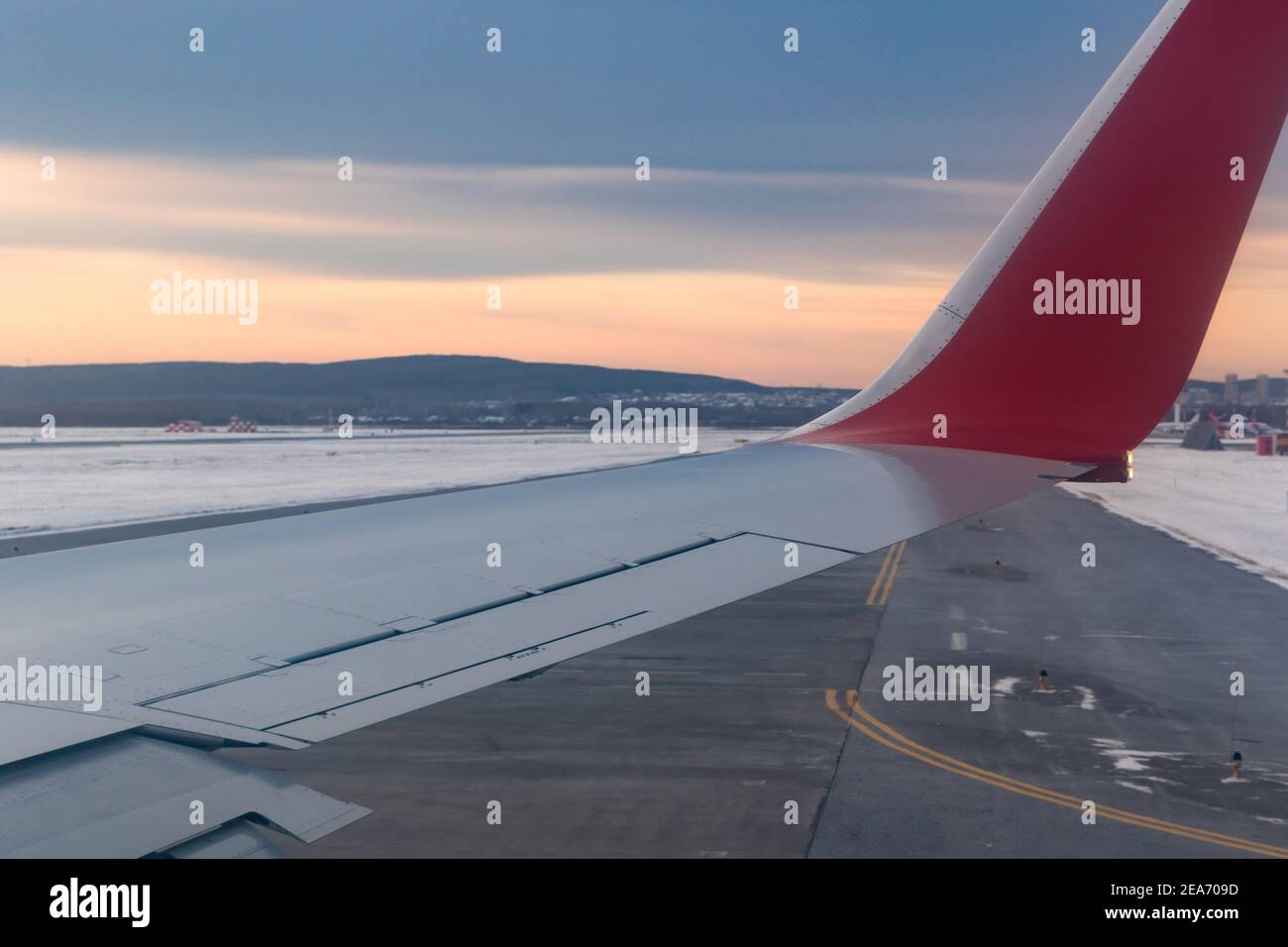 view from the airplane window of the airport runway and part of the ...