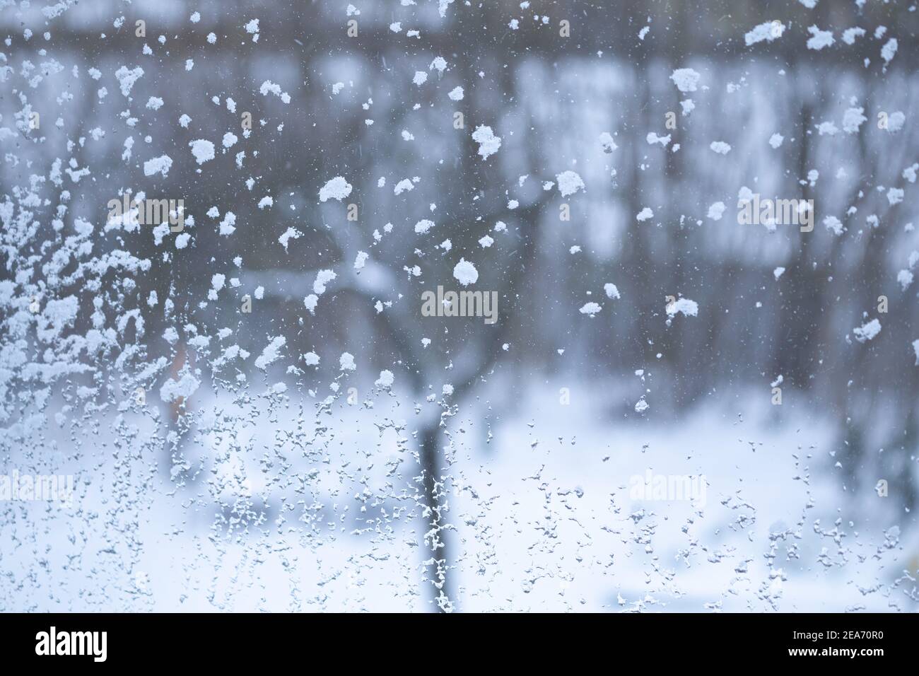 Cold weather and snow storm view from inside home. Window covered with ...