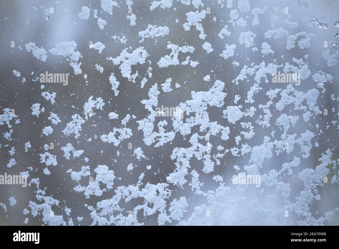 Cold weather and snow storm view from inside home. Window covered with ...