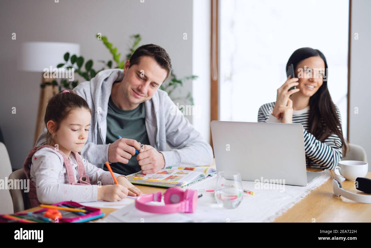 Parents with school girl indoors at home, distance learning and home ...