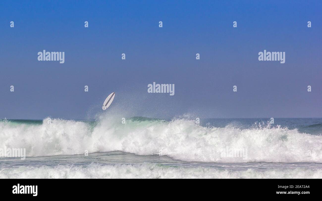 Surfboard on sea waves under a bright sky Stock Photo - Alamy
