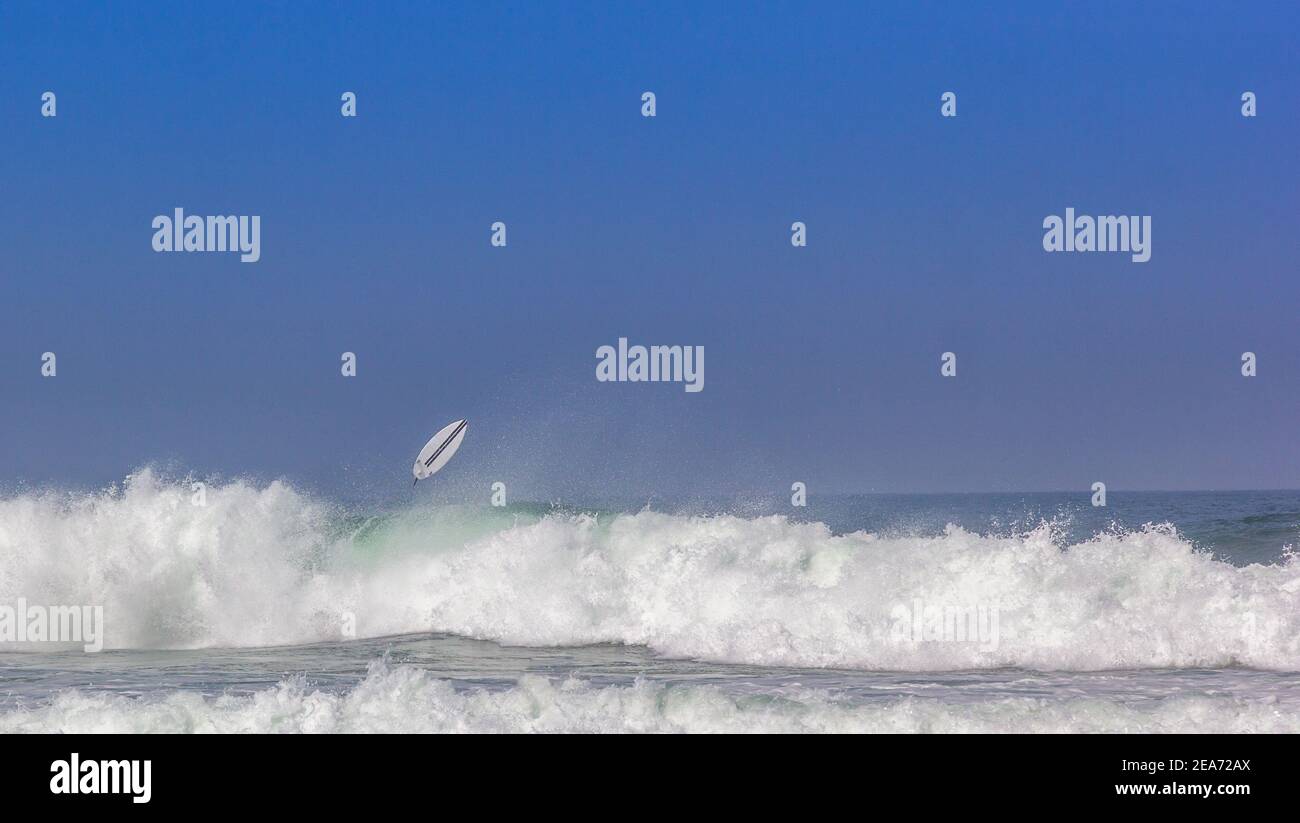 Surfboard on sea waves under a bright sky Stock Photo - Alamy