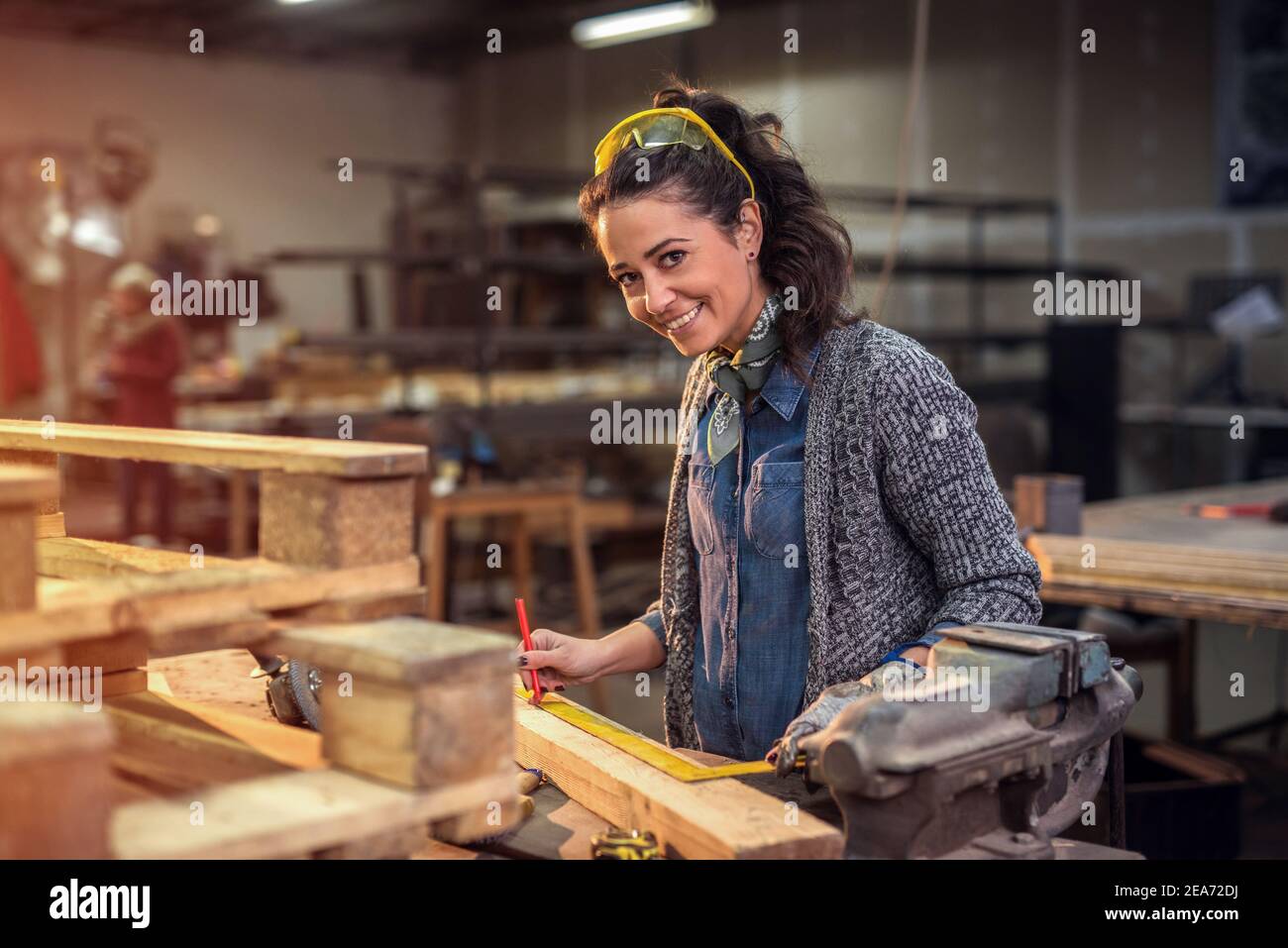 Middle aged professional female carpenter looking at the camera while ...
