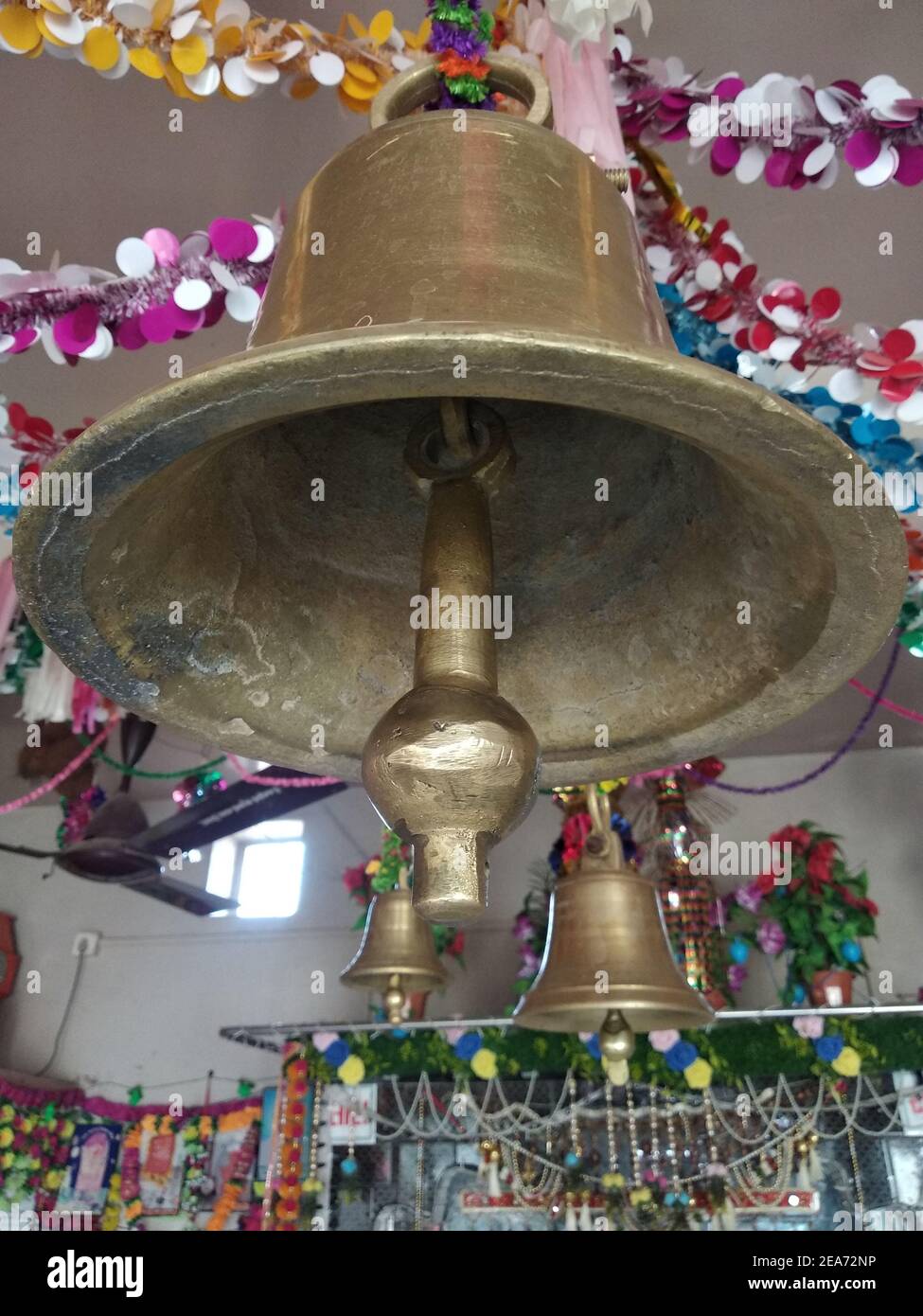 Vertical shot of big metallic bells hanging from the ceiling surrounded ...