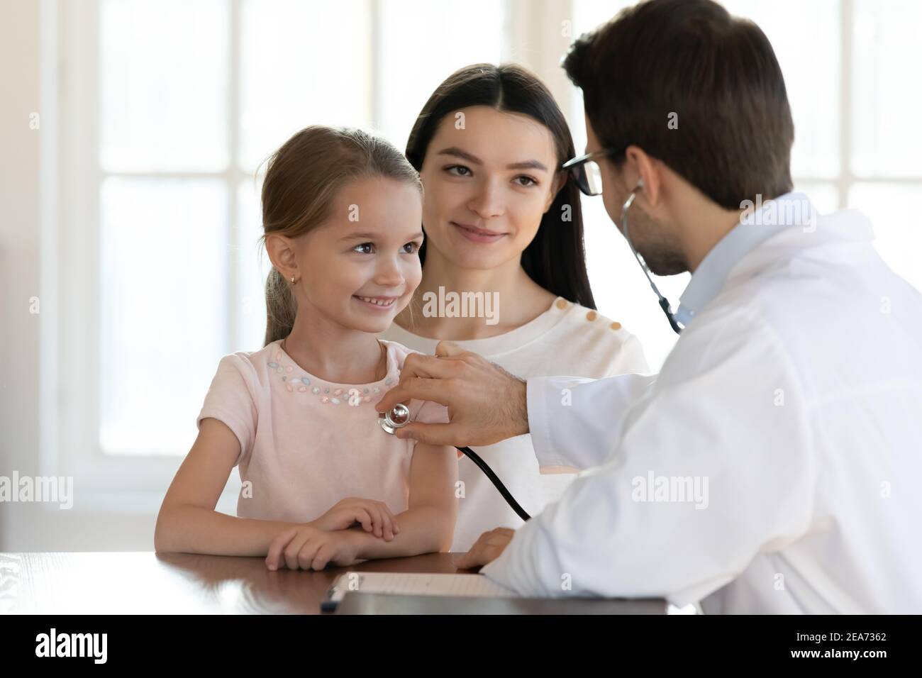 Caring male doctor listen to small child patient heart Stock Photo - Alamy