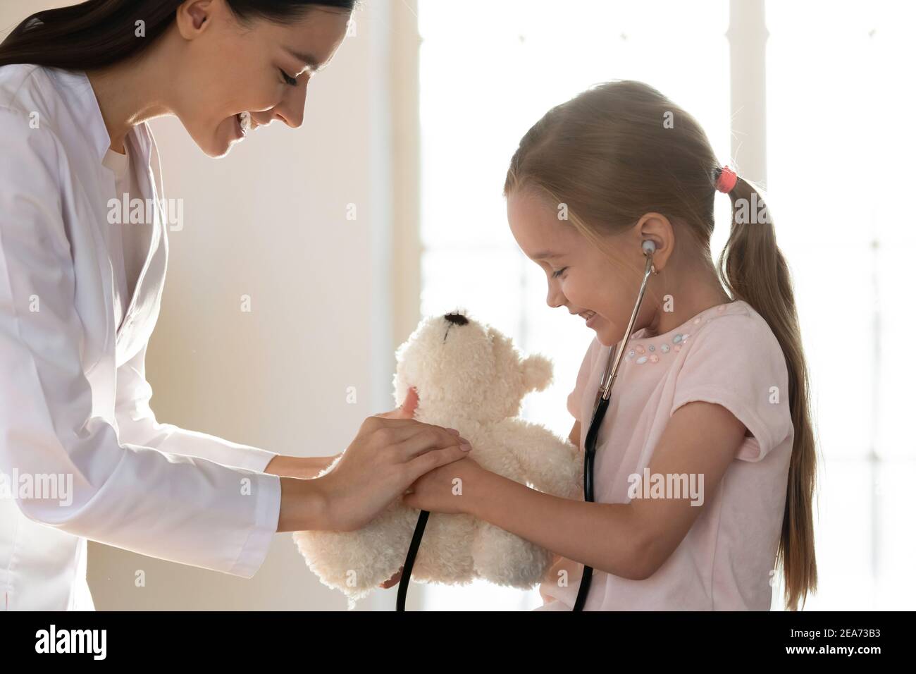 Caring female doctor play with small girl patient Stock Photo - Alamy