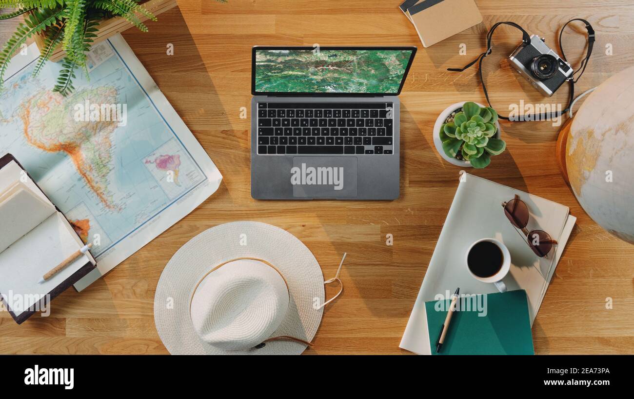 Flat lay top view desktop travel concept with laptop, maps and other ...