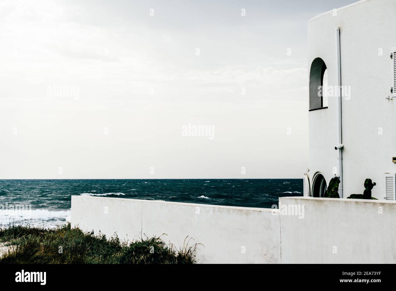 Beautiful modern white building with the view of the wavy sea under the ...